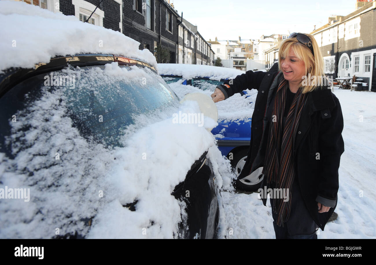 A woman clears snow off her car Stock Photo - Alamy