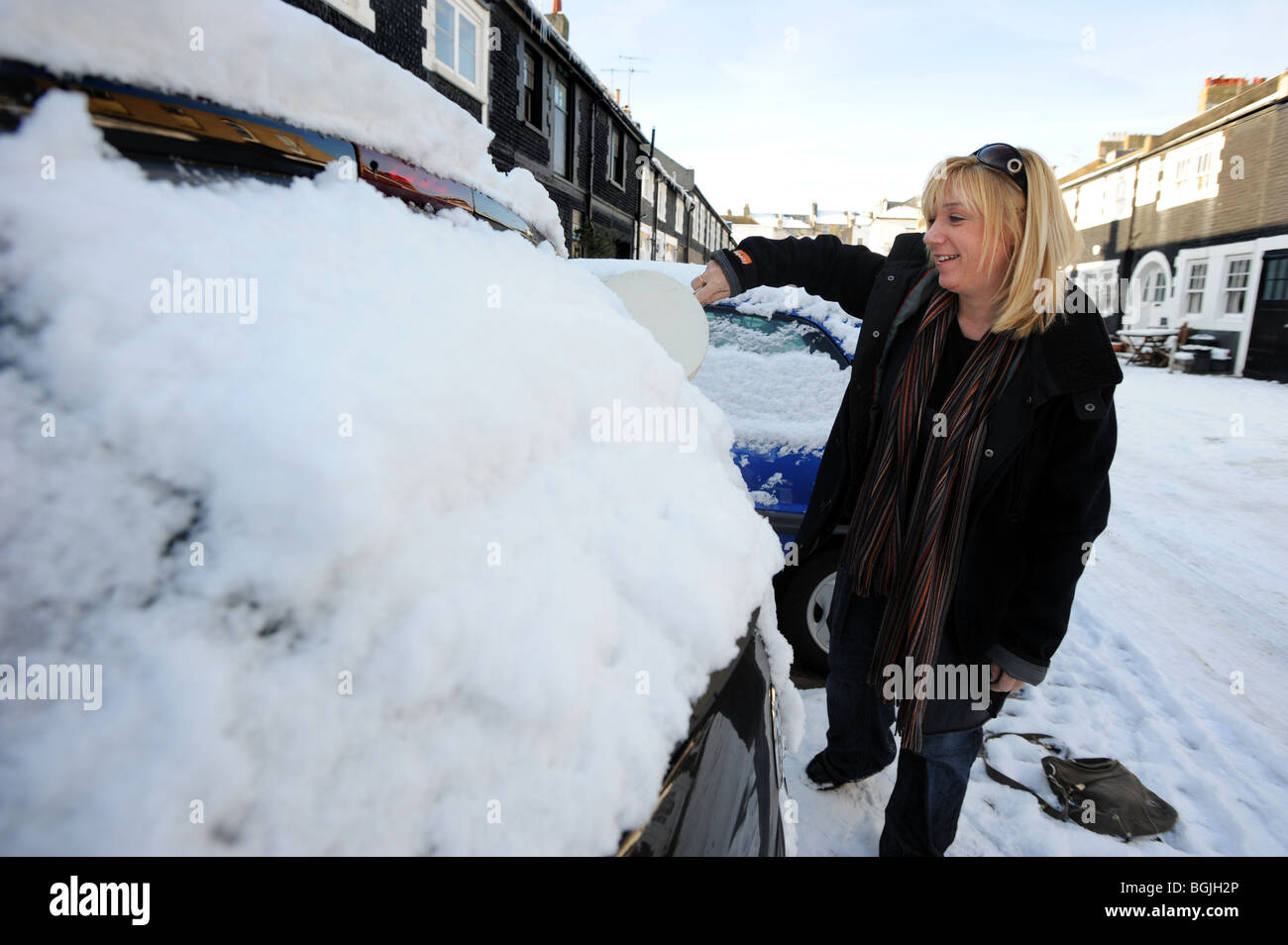 A woman clears snow off her car Stock Photo - Alamy