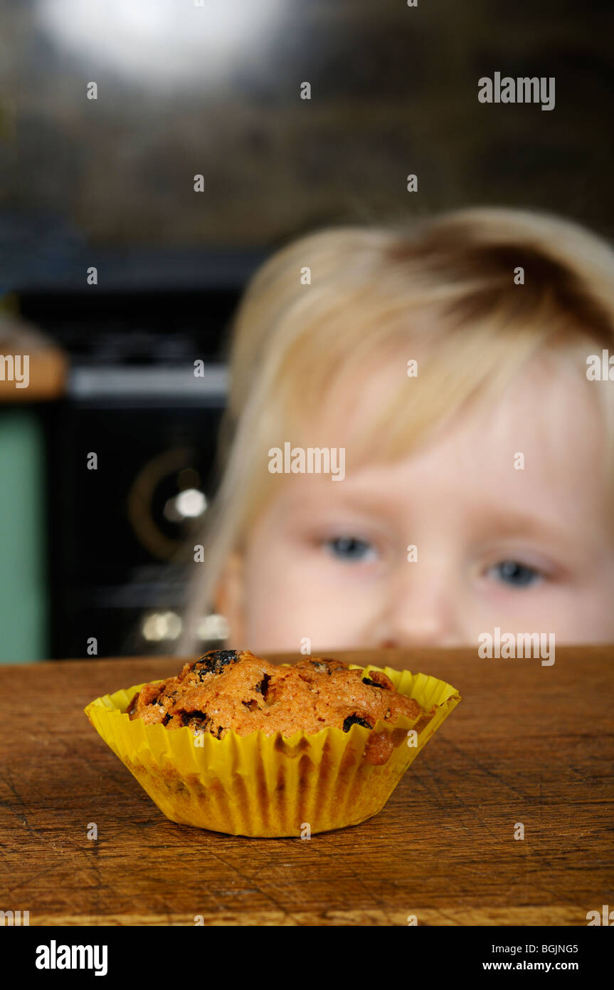 Stock photo of a little girl looking longingly at a cake on the kitchen ...