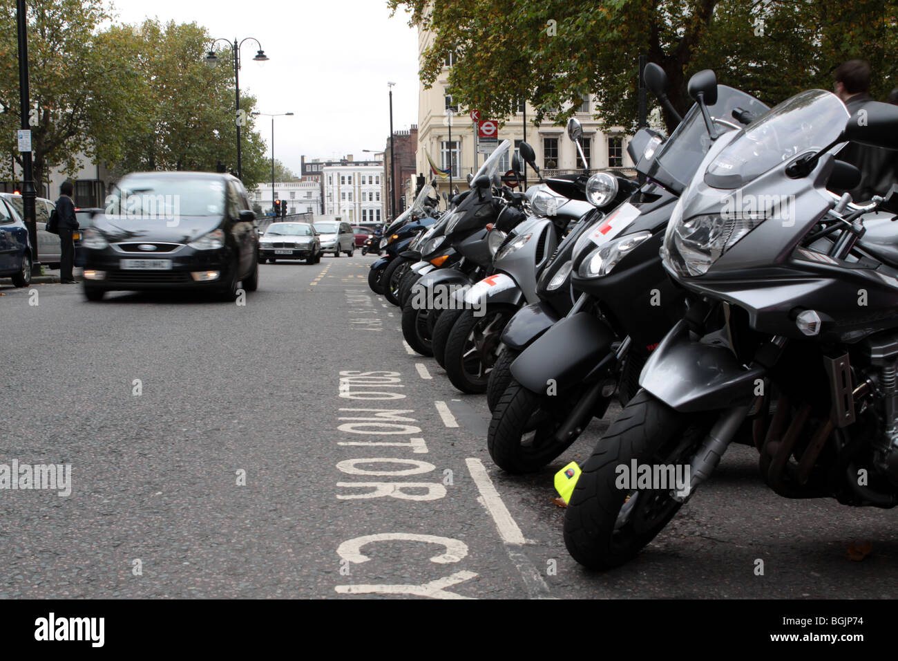 motorcycles in London parked on the side of the road with cars passing ...