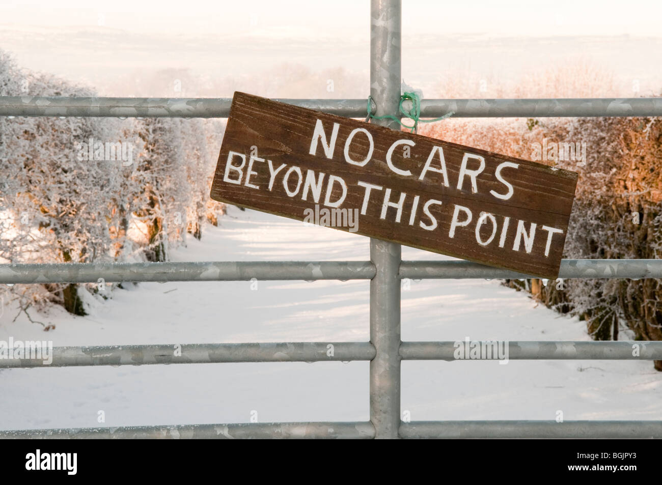 Sign saying "No cars beyond this point" leading to a snow covered lane ...