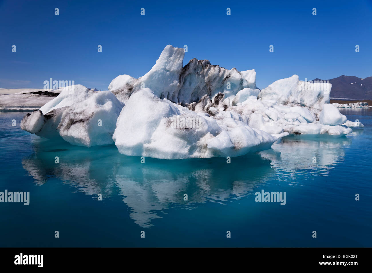 A glacial iceberg and its symmetrical reflection floating on the ...