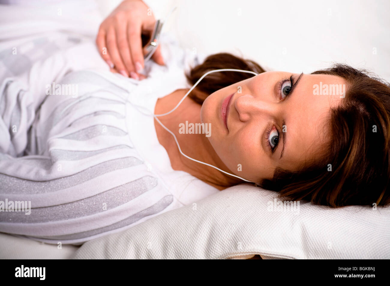 Young woman listening to music on MP3 player Stock Photo - Alamy