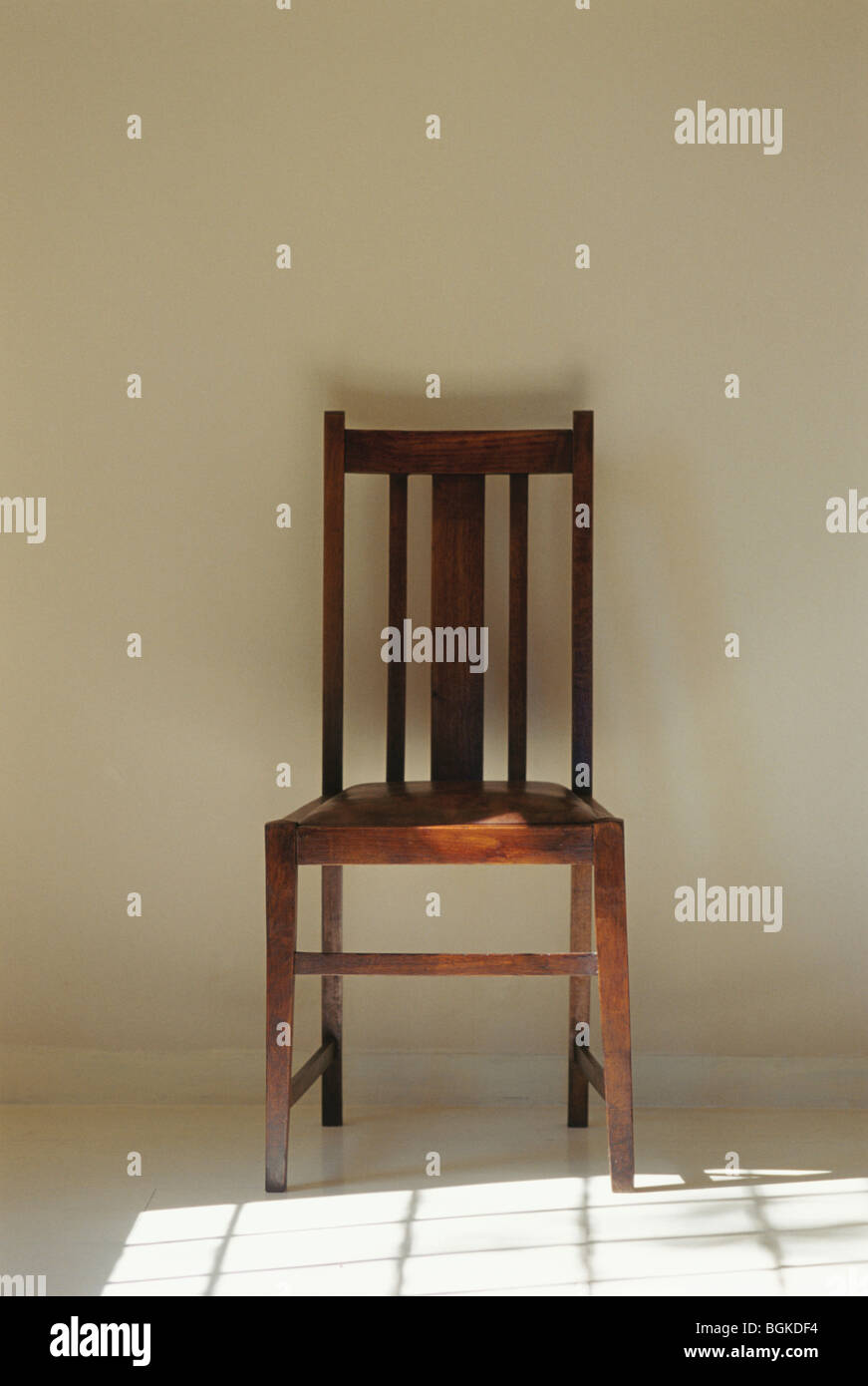 Wooden chair next to shadow cast by window Stock Photo - Alamy