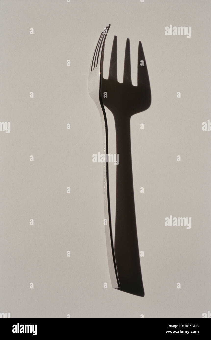 Silver fork with shadow on white background Stock Photo - Alamy