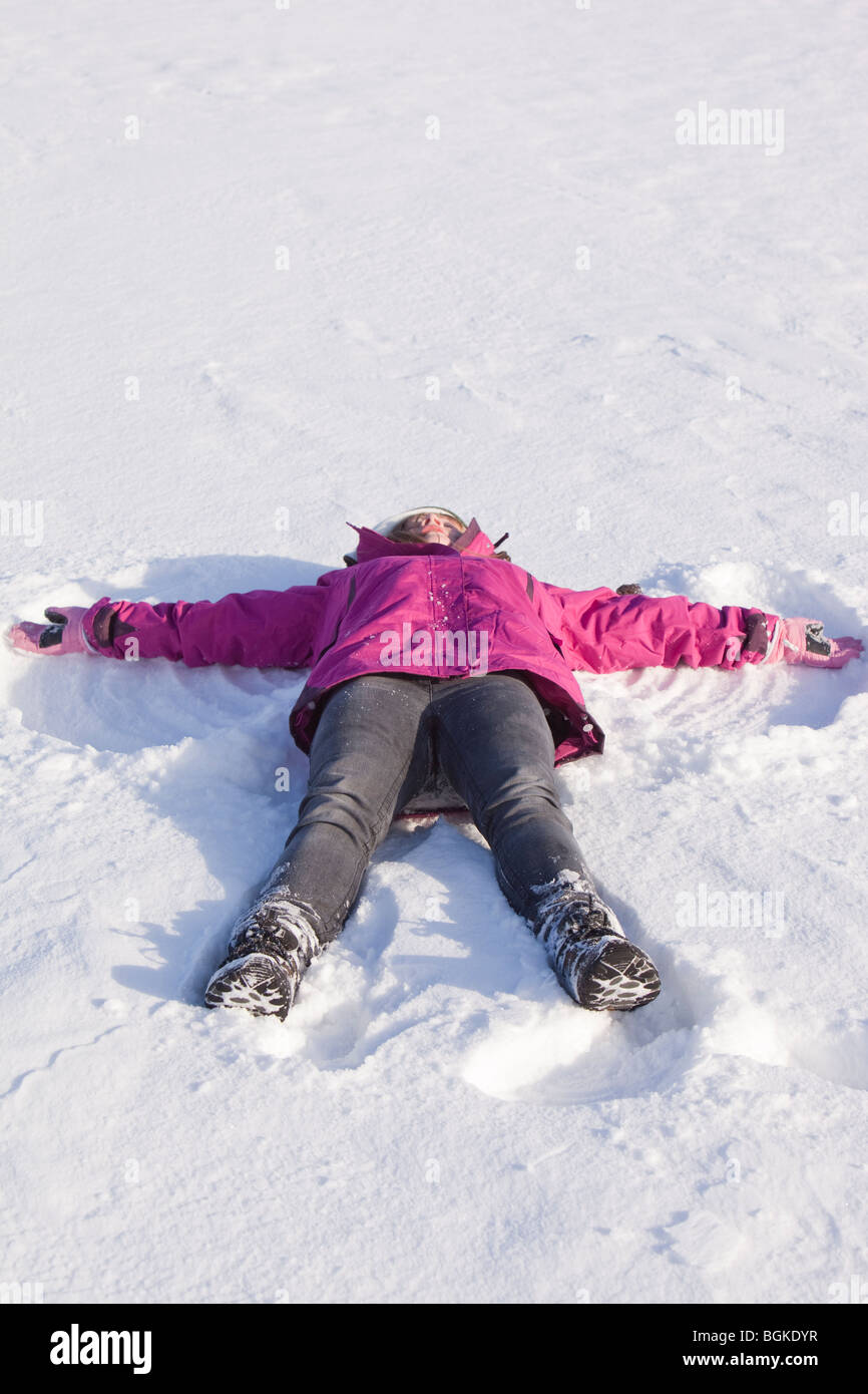 A young girl making a snow angel Stock Photo - Alamy