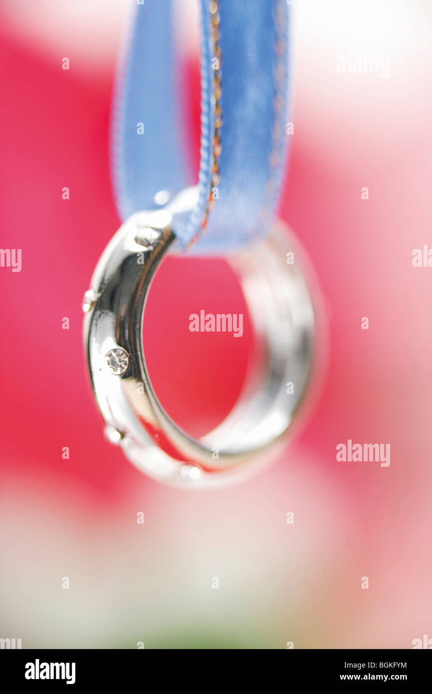 Diamond ring hanging from a blue ribbon Stock Photo - Alamy