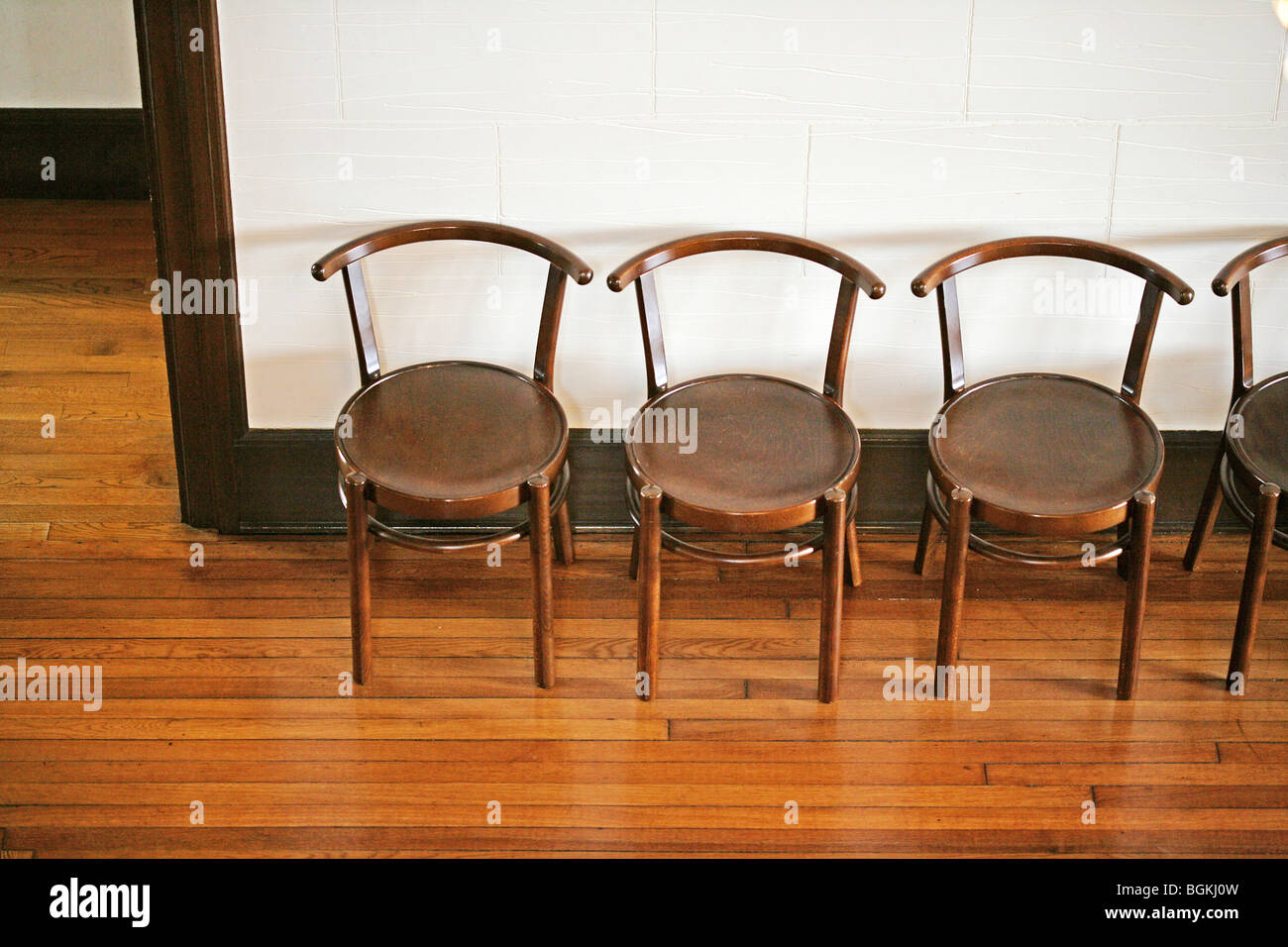 Chairs lined up against a wall Stock Photo - Alamy
