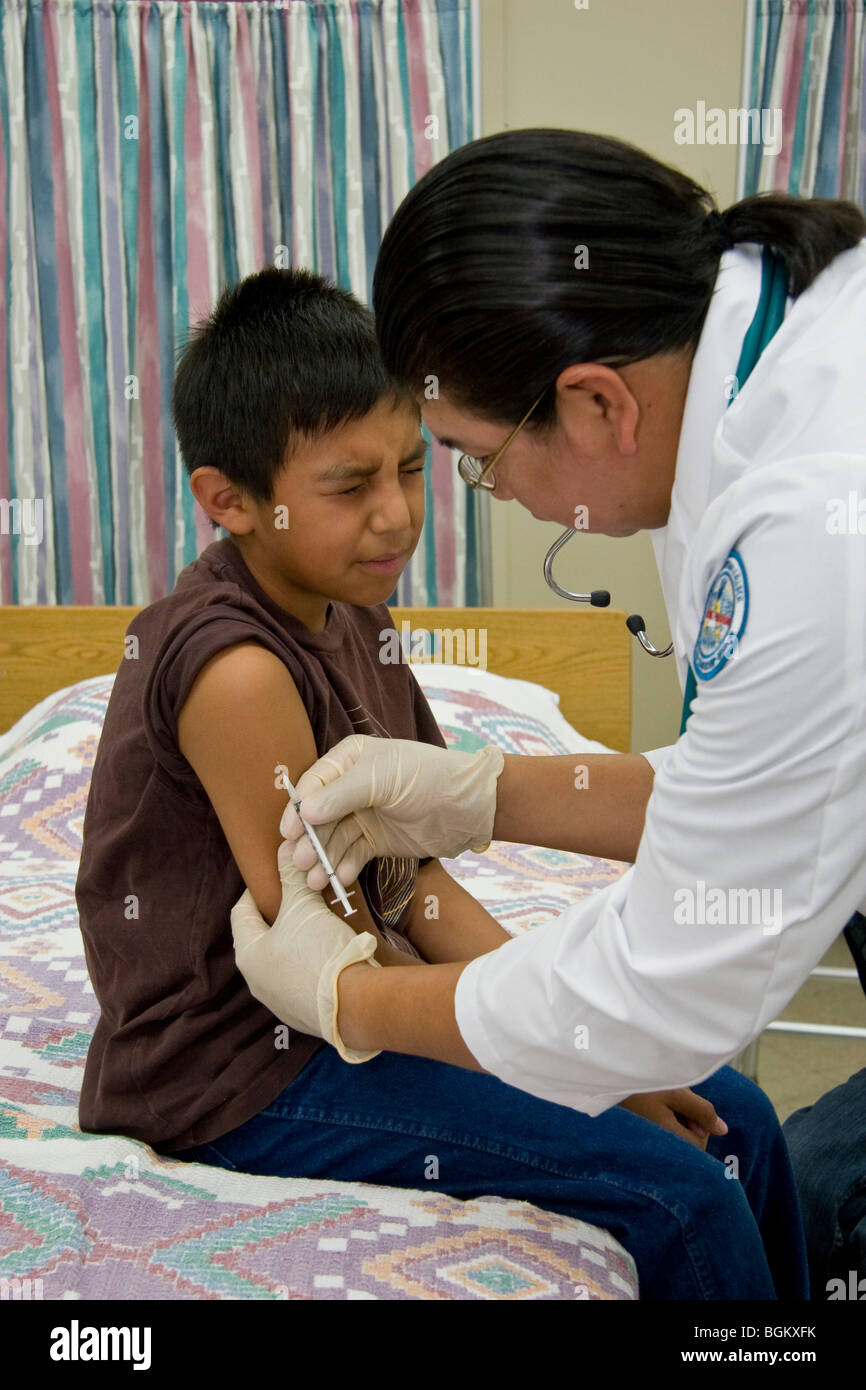 Young patient shows his fear and pain of needles while getting a shot ...