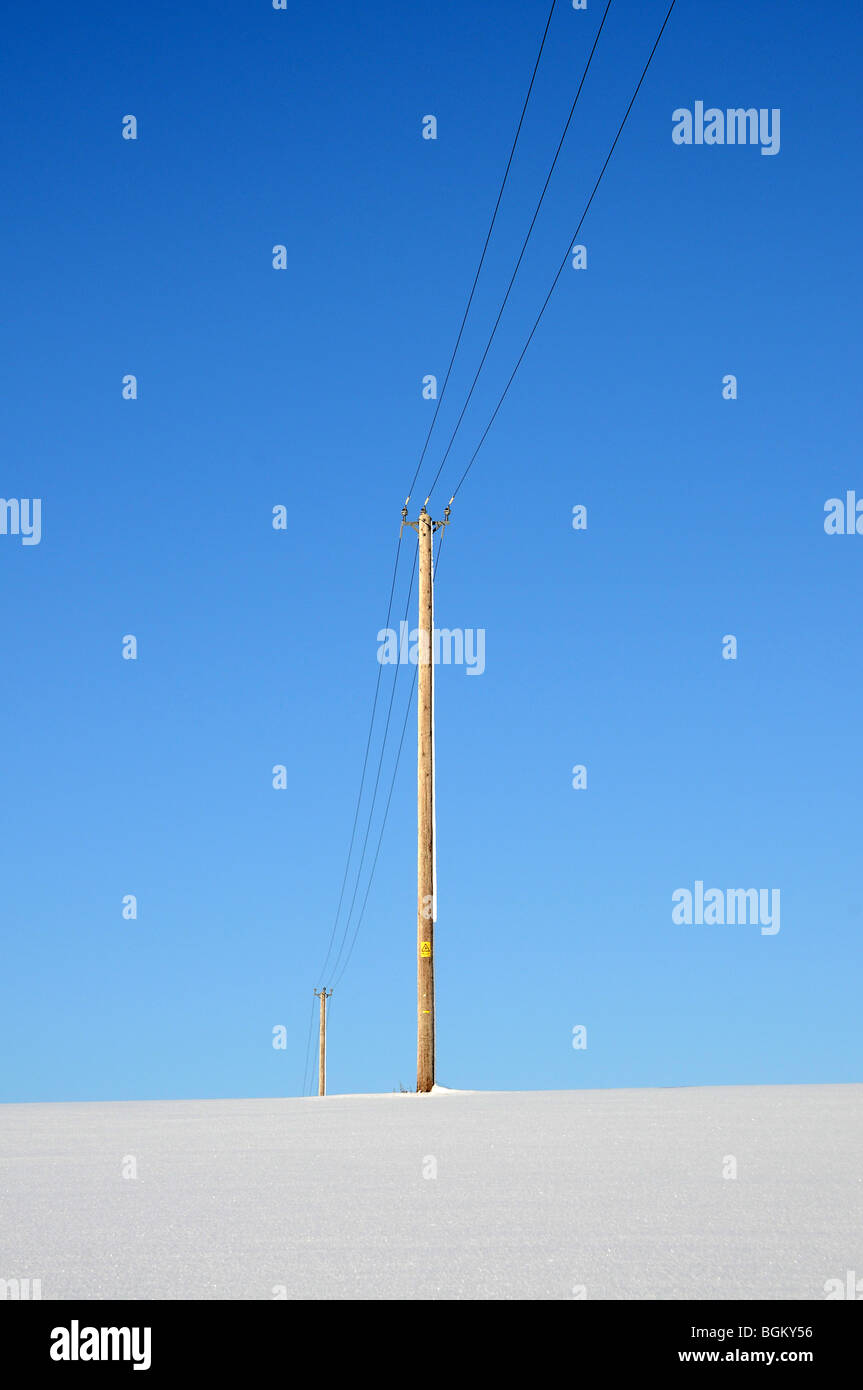 power lines and poles over a snow covered field Stock Photo - Alamy