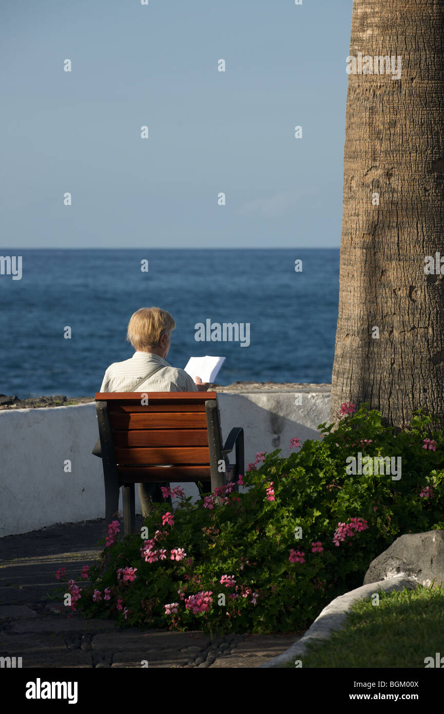 Woman reading a book in front of the ocean, Tenerife Stock Photo - Alamy