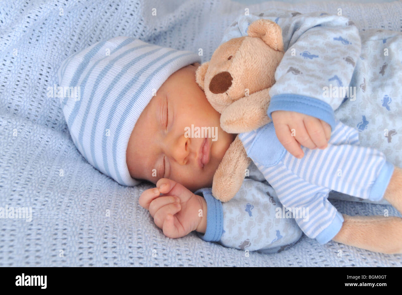 Newborn baby sleeping hugging his toy Stock Photo - Alamy