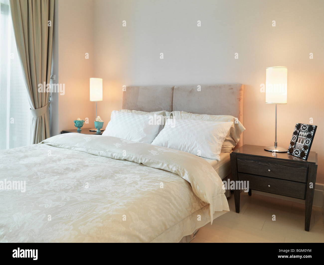 Light colored bed in modern bedroom Stock Photo - Alamy