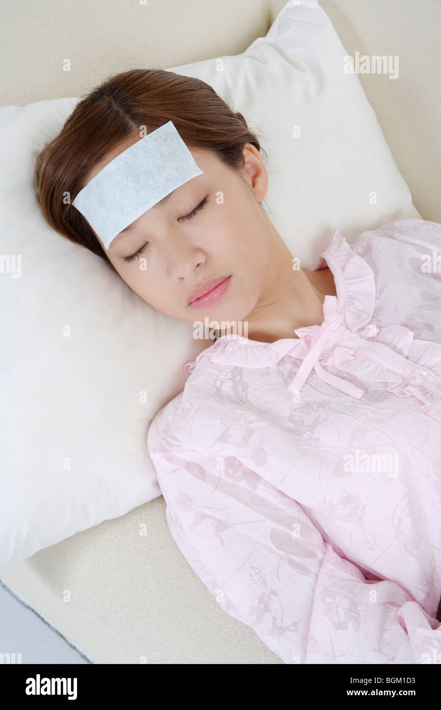 Young woman of a fever, testing on bed Stock Photo - Alamy