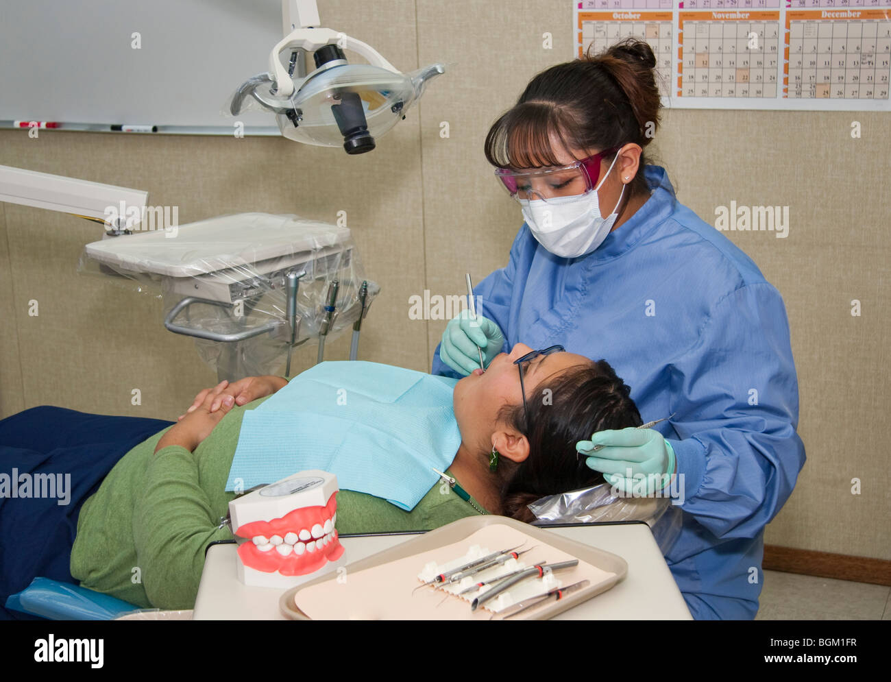 Native American dental technician cleans a patients teeth during a ...
