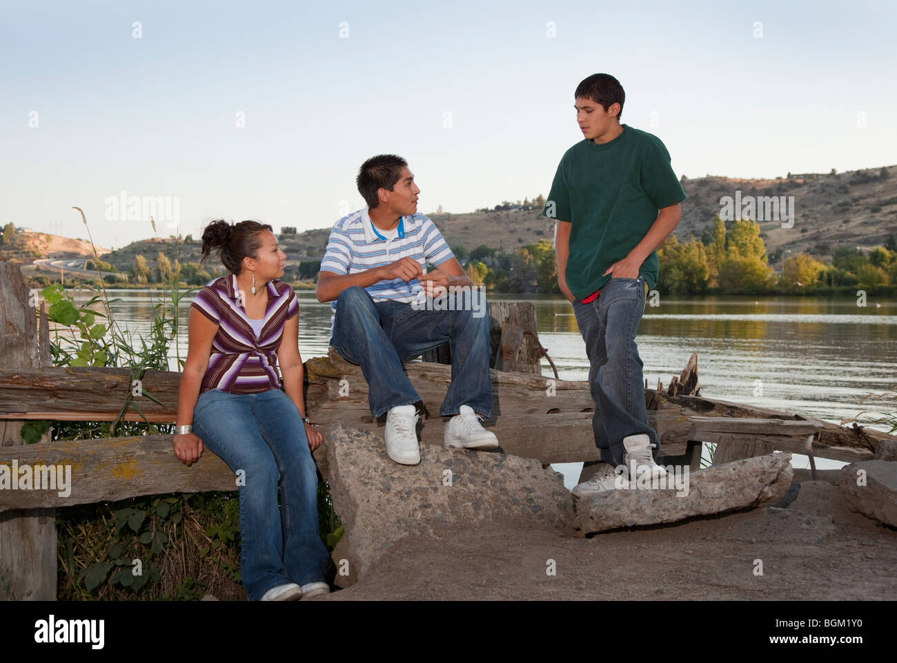 Three Native American teenagers talk while they hang out together on ...