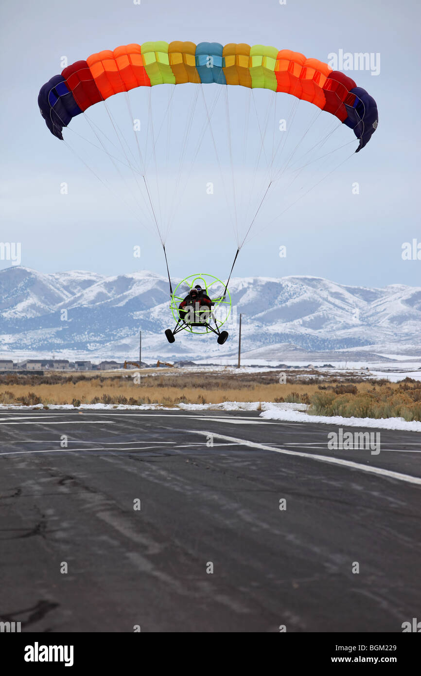 Powered parachute flying a low approach to land on a runway during ...
