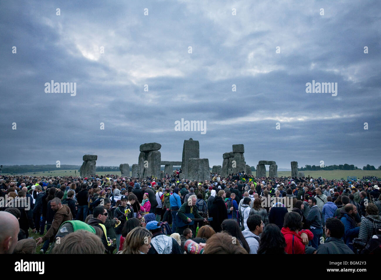 Crowds of people surround Stonehenge on the dawn of the summer solstice ...