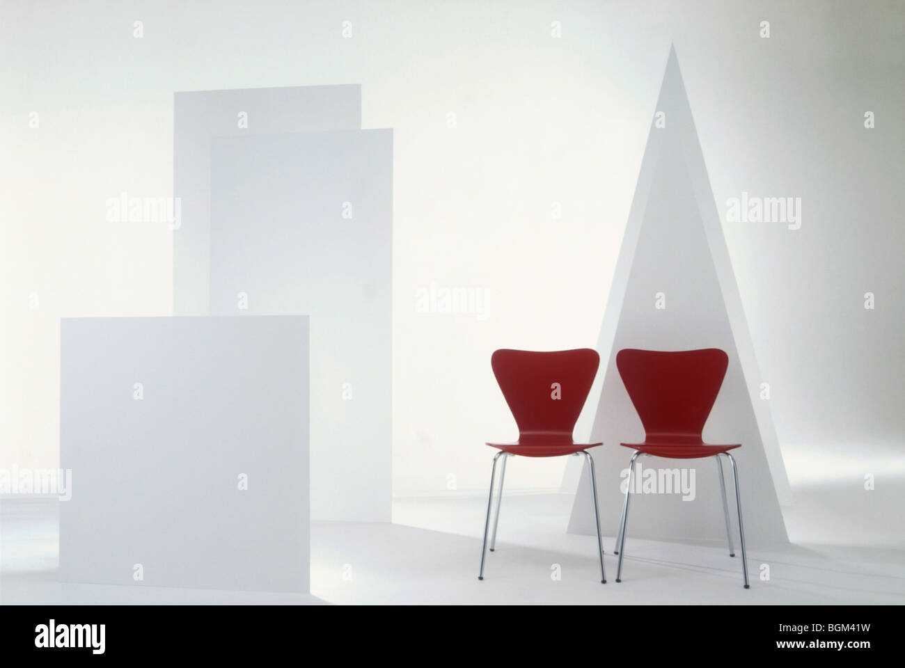 Two red chairs in room with white shapes Stock Photo - Alamy