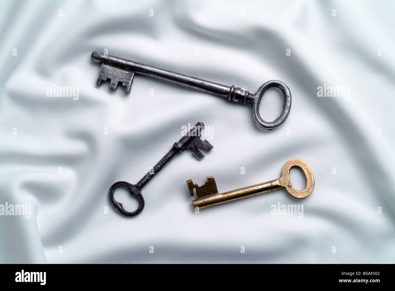 Keys on white silk Stock Photo - Alamy