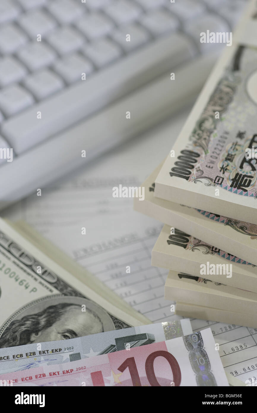 Bundles of different currency and a computer keyboard Stock Photo - Alamy