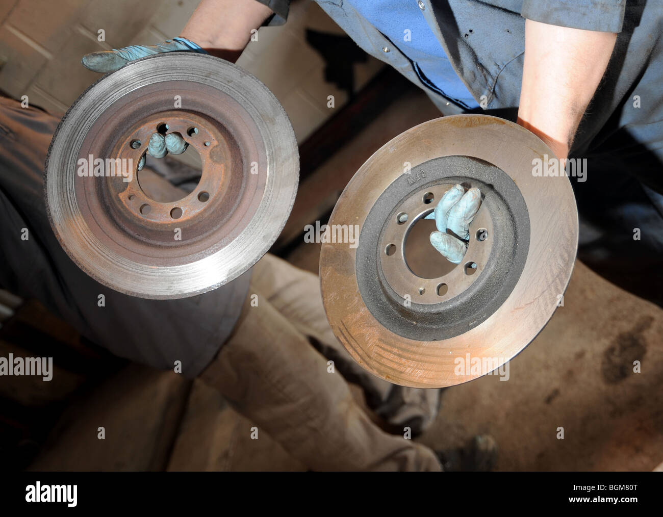 Old and new car brake disks compared - worn on left scored, rusty with ...