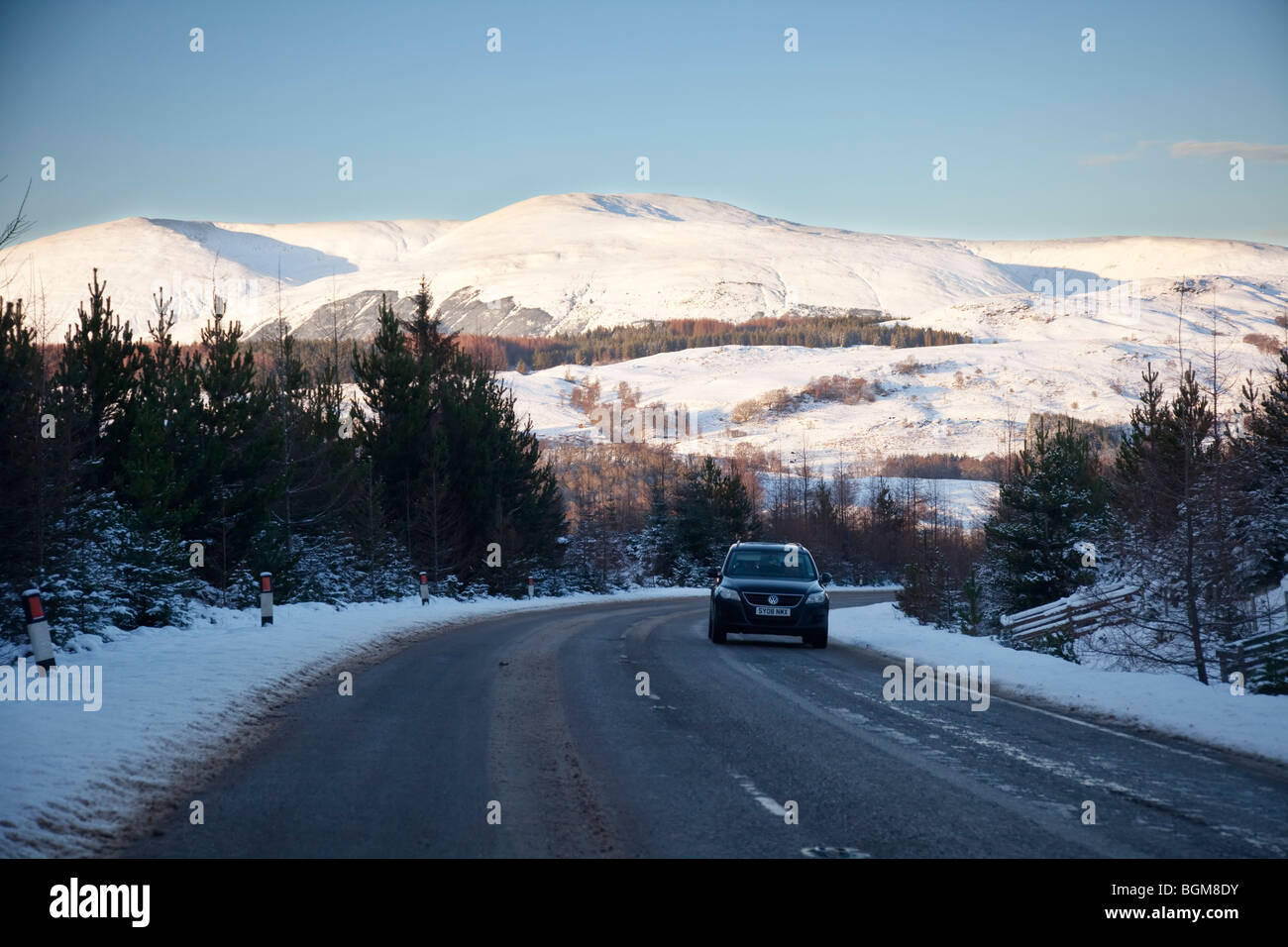 Car driving on snow cleared road Stock Photo - Alamy