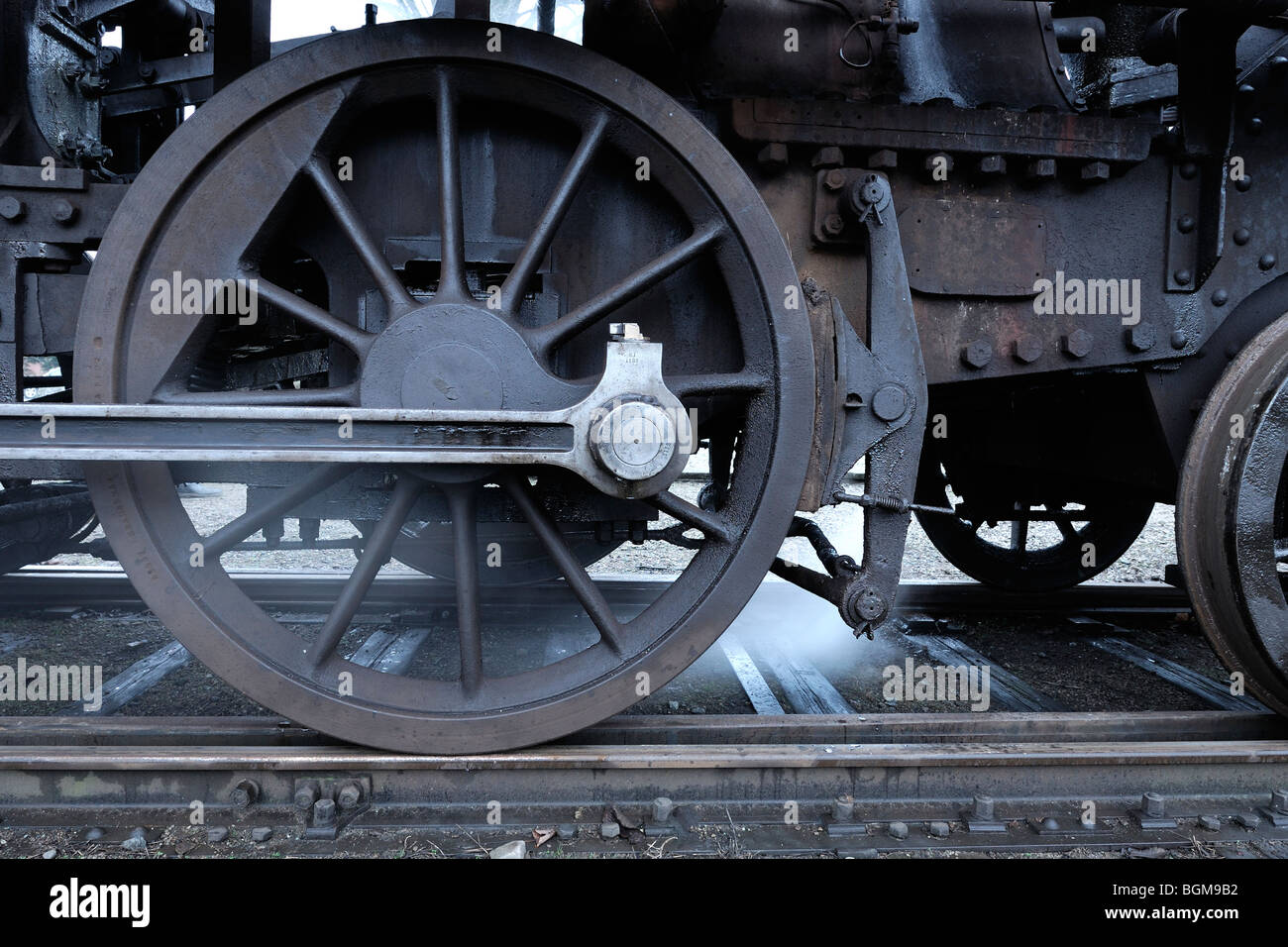 A big iron wheel on an old steam powered locomotive standing at the ...