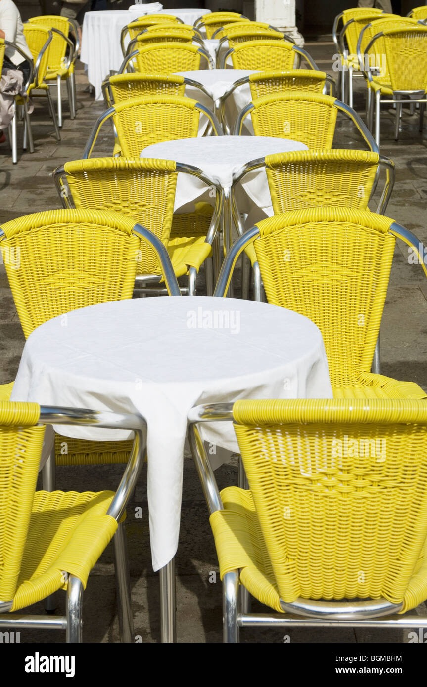 Bright yellow chairs and white clothed tables of outdoor cafe' in St ...