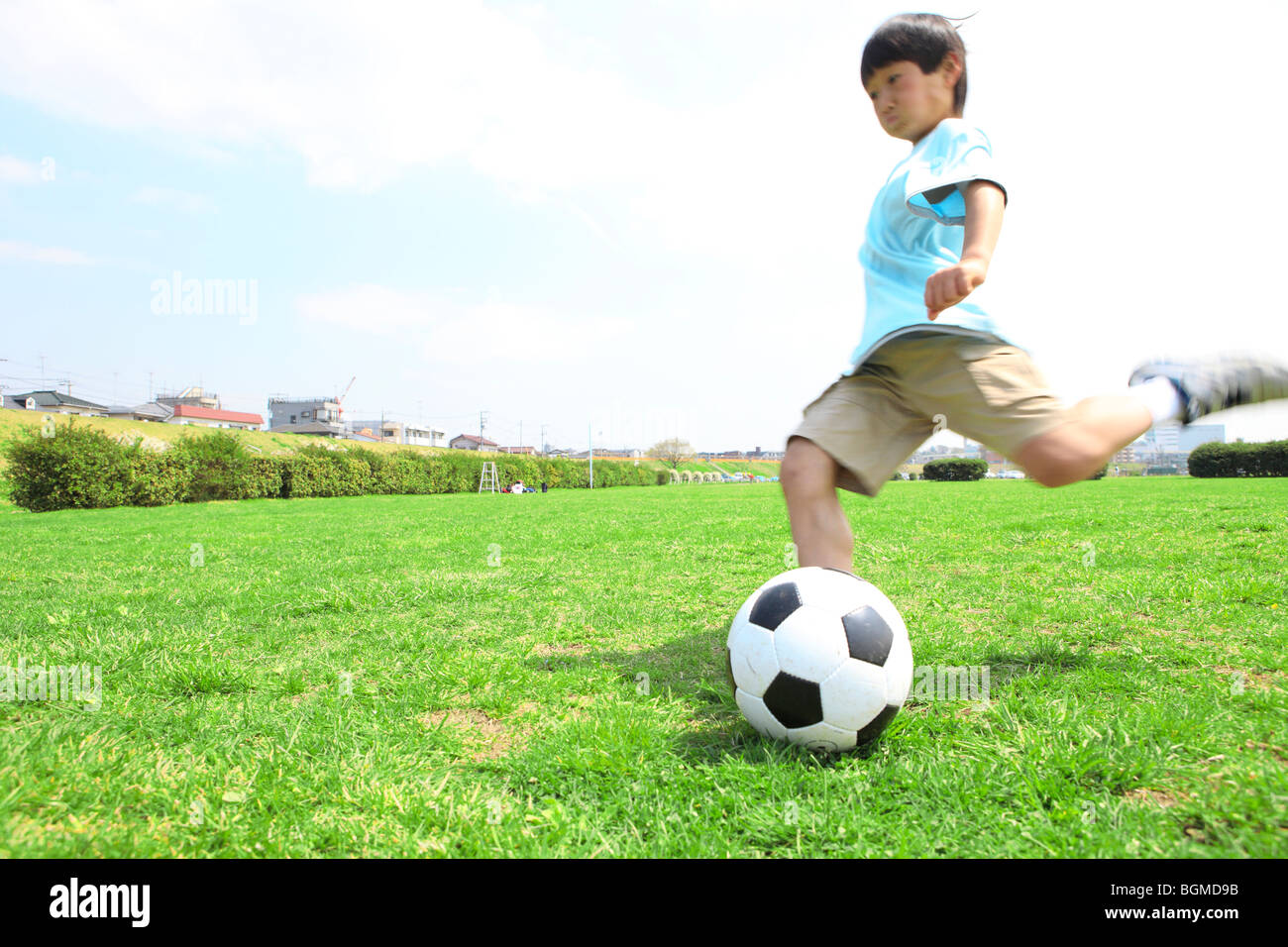 Young boy kicking soccer ball on field. Futako-tamagawa Setagaya-ku ...