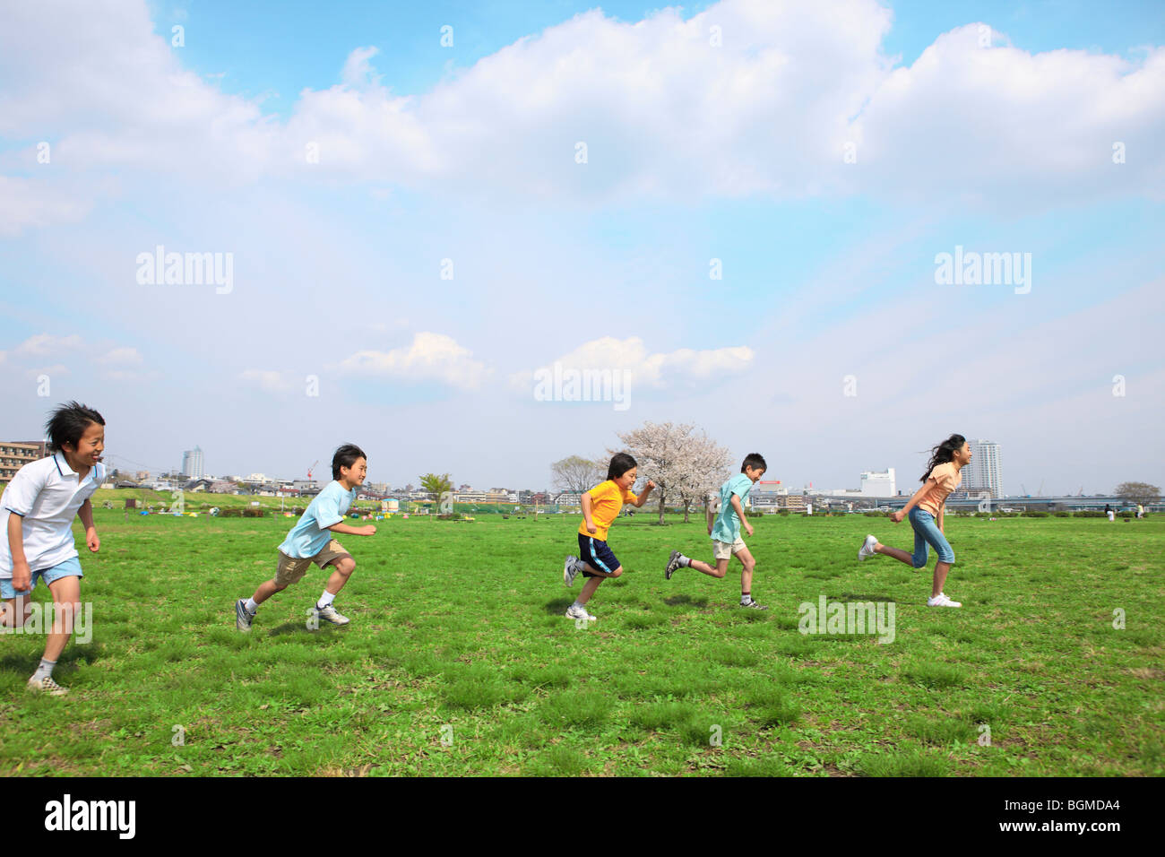 Five children running on field. Futako-tamagawa, Setagaya-ku, Tokyo ...