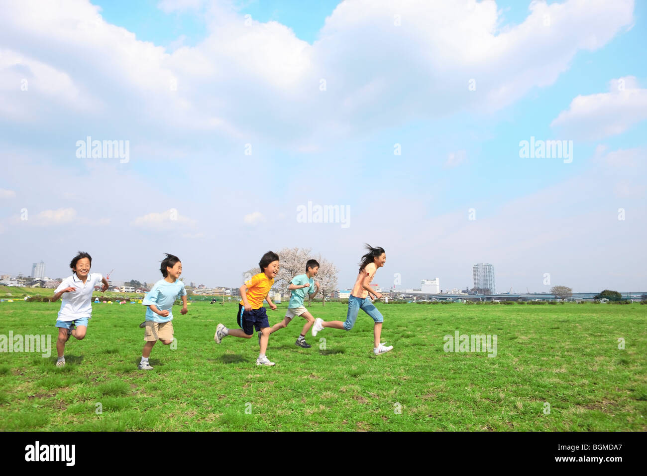 Five children running on field. Futako-tamagawa, Setagaya-ku, Tokyo ...