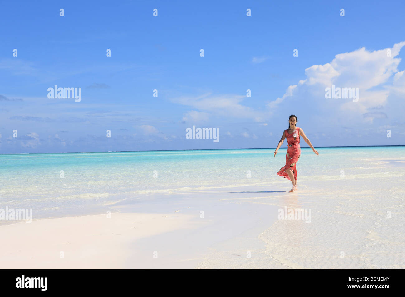 Woman walking through shallow water at the beach, Maldive Islands Stock ...