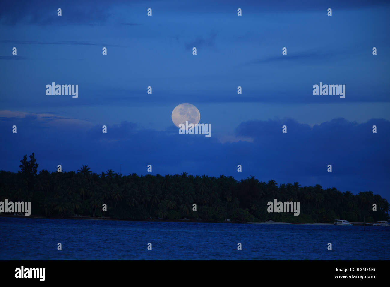 Full moon setting over island, Maldive Islands Stock Photo - Alamy