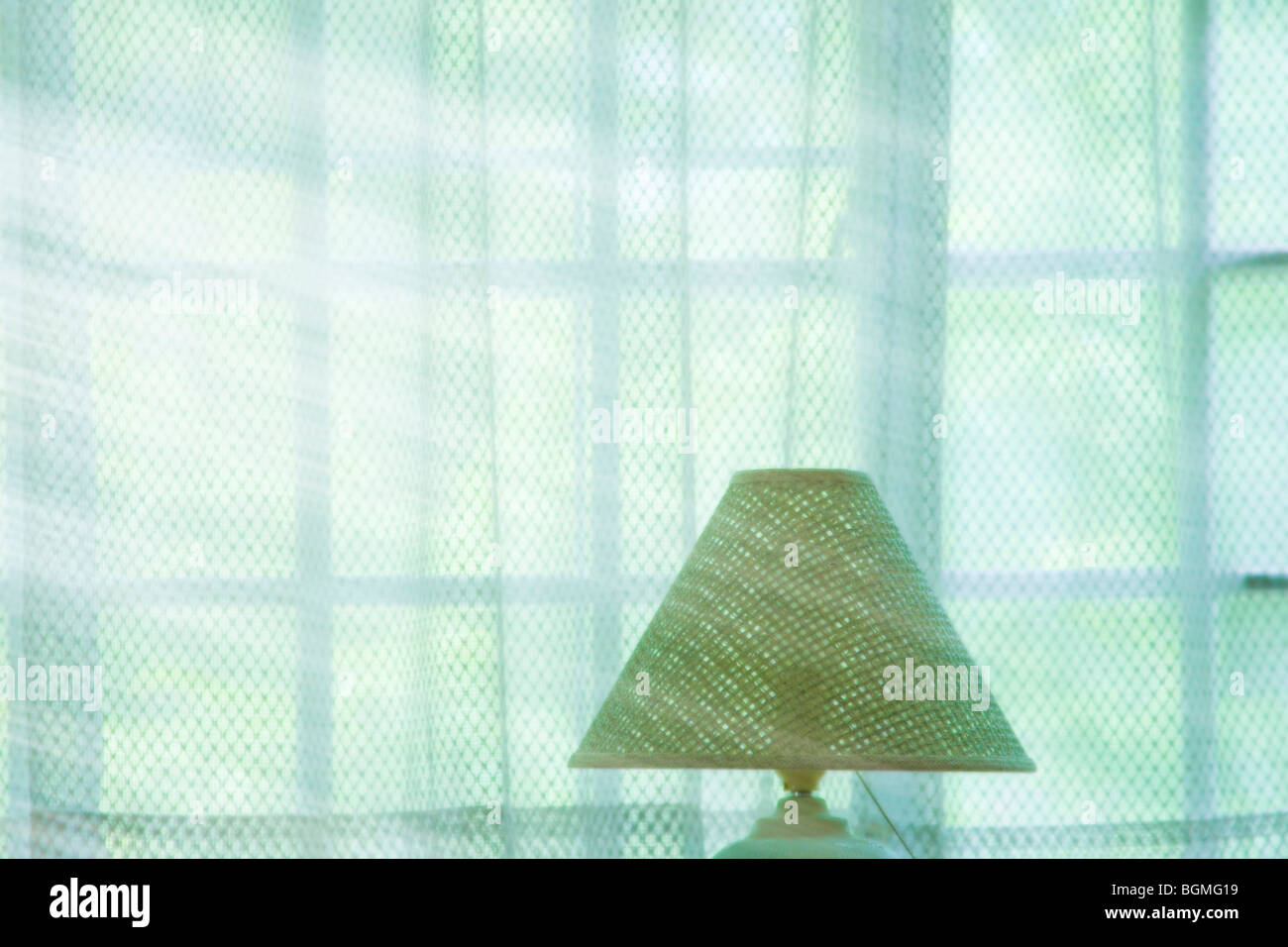 Desk lamp by window with green curtains Stock Photo - Alamy