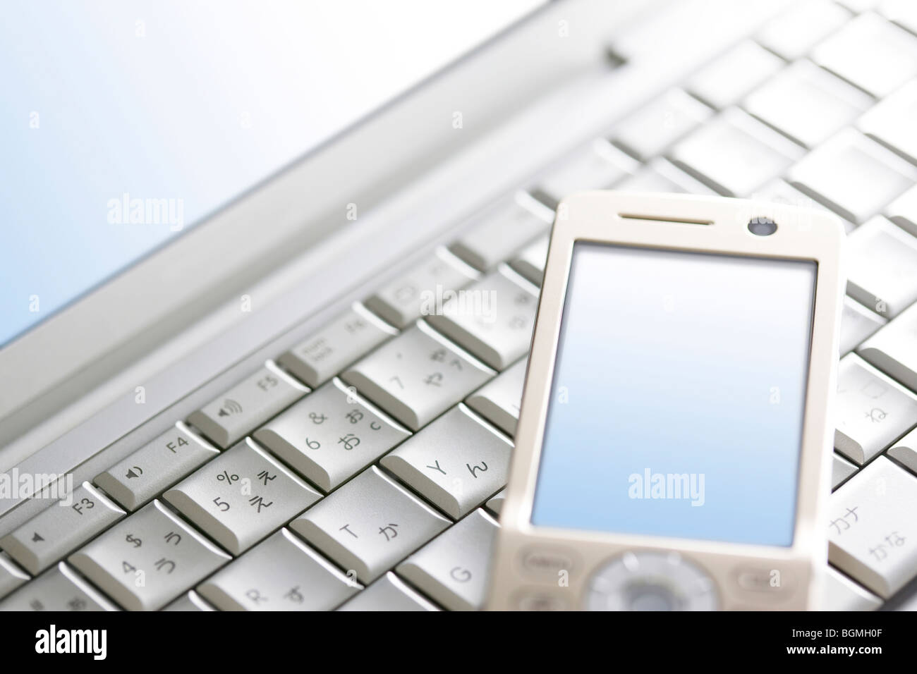 Cell phone on laptop keyboard Stock Photo - Alamy