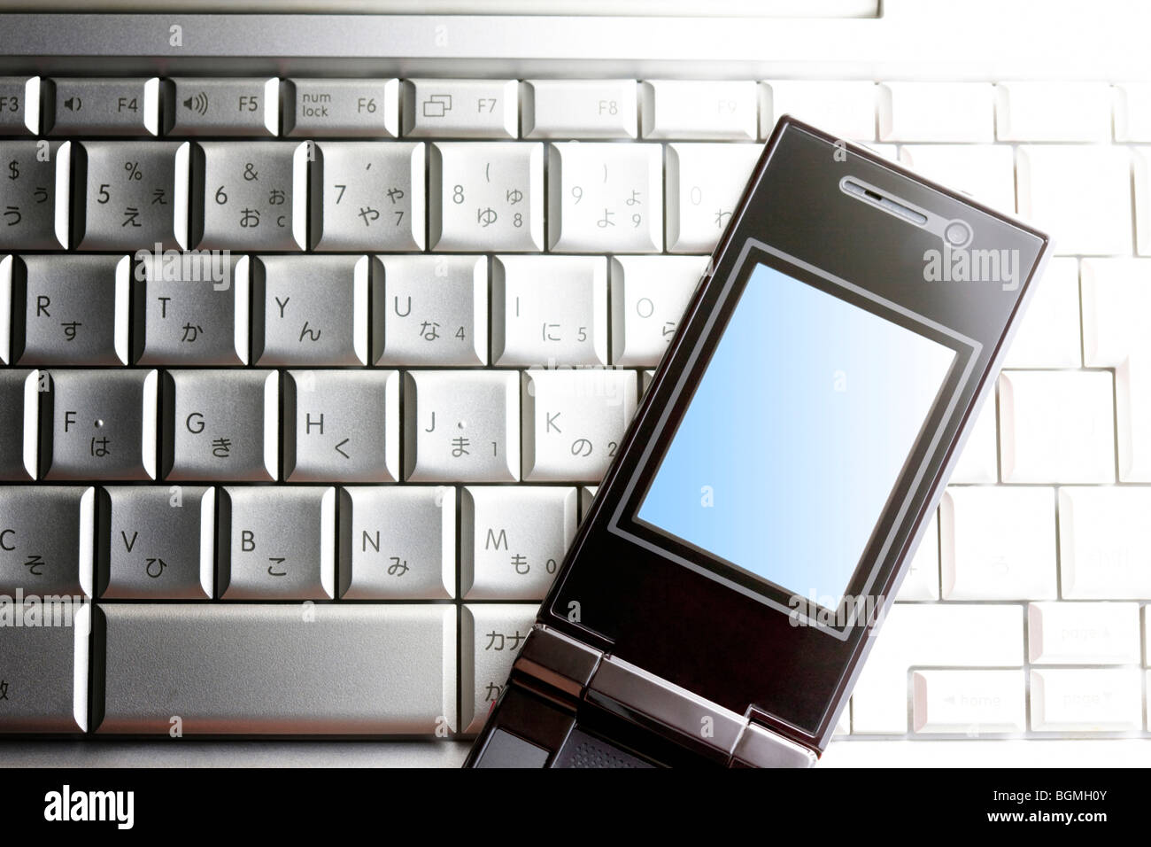 Cell phone on laptop keyboard Stock Photo - Alamy