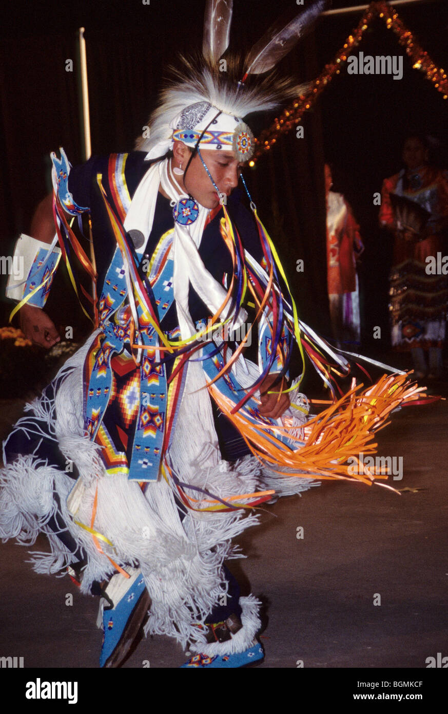 Young man dressed in pow wow regalia demonstrates a grass dance during ...