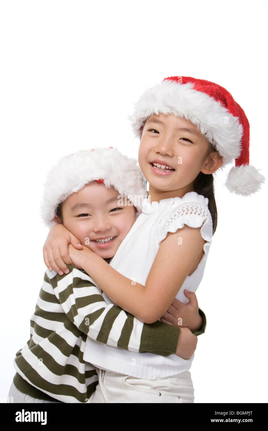 Boy and girl with Santa hats Stock Photo - Alamy