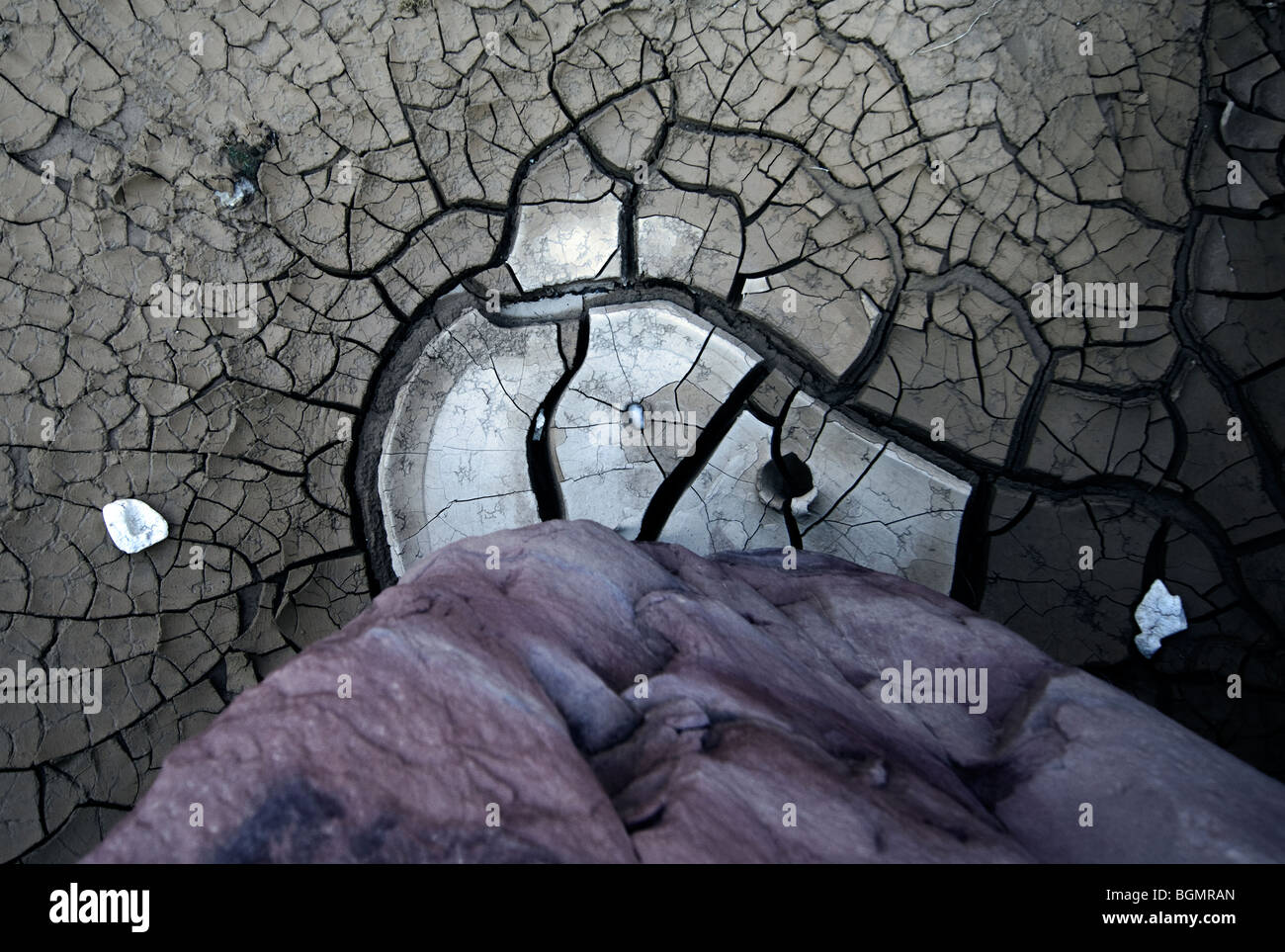 Rock protrusion over a patch of semi dry mud Stock Photo - Alamy
