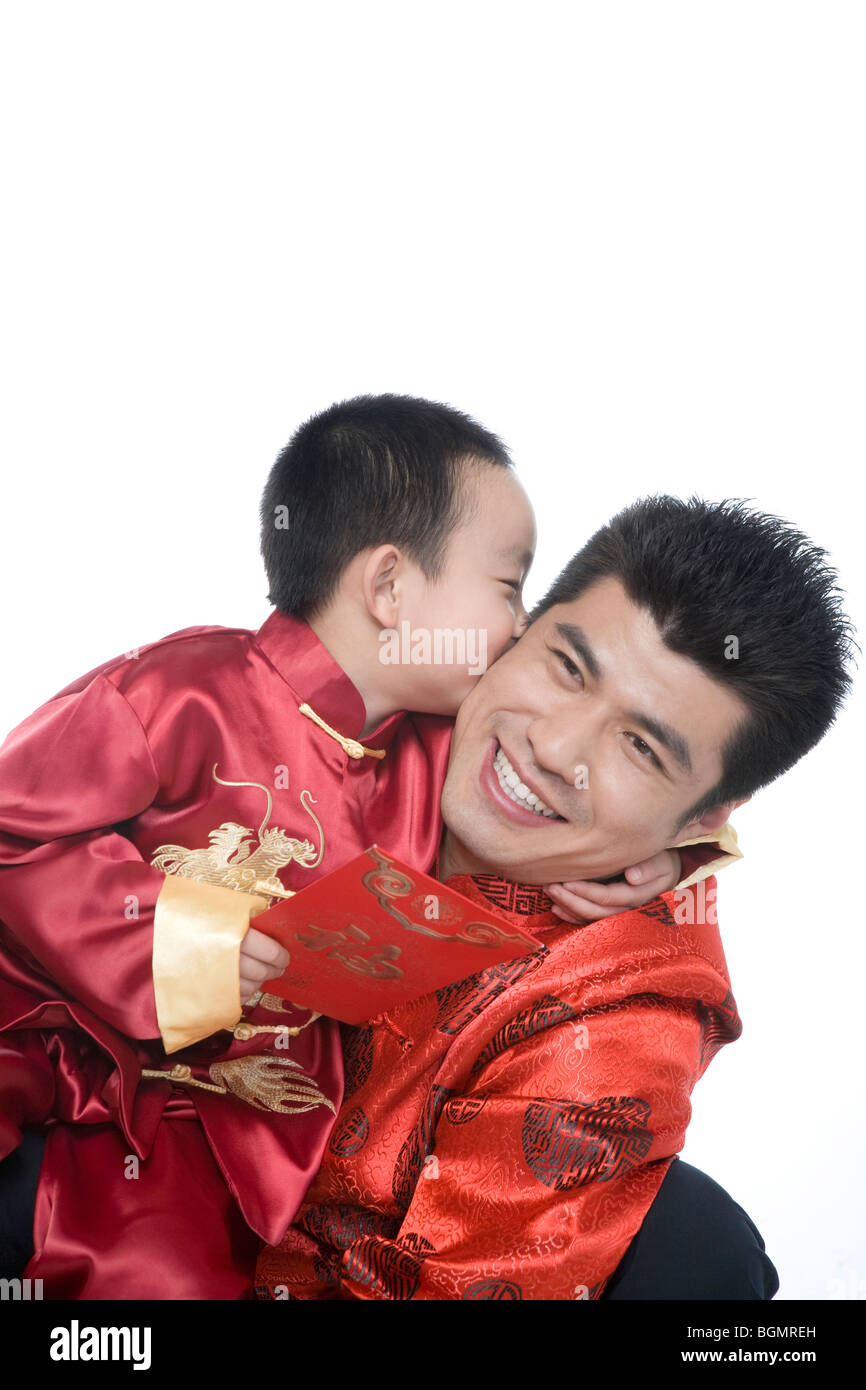 Father and son in Chinese traditional clothes holding red envelope ...