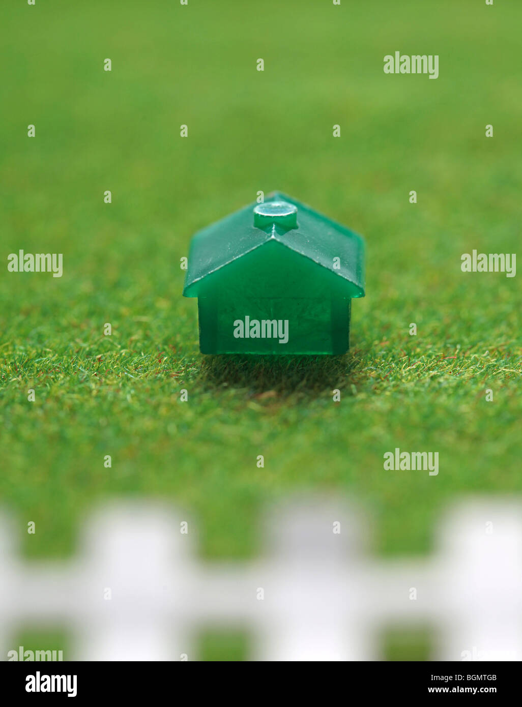 Monopoly house on green grass with white picket fence Stock Photo - Alamy