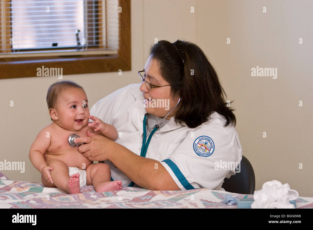 Student nurse at Native American college examines baby with stethoscope ...