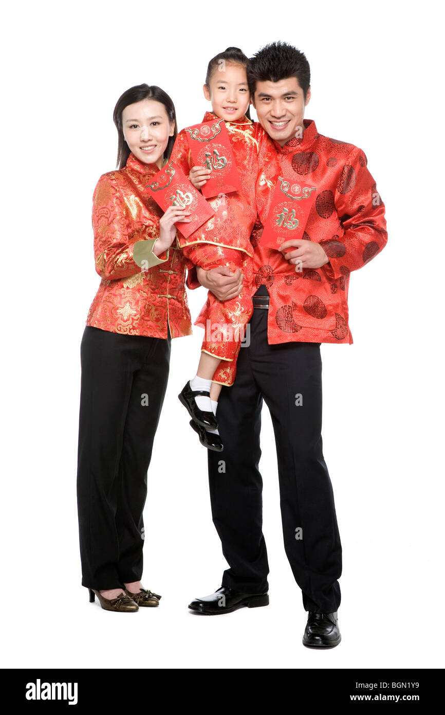 Family of three in Chinese traditional clothes holding red envelopes ...