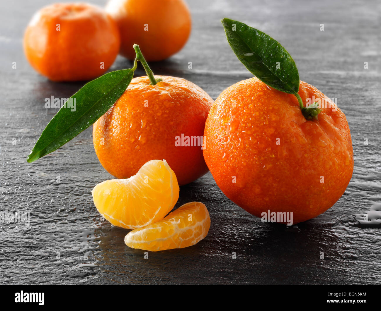 Fresh whole and cut mandarins against a black background Stock Photo ...