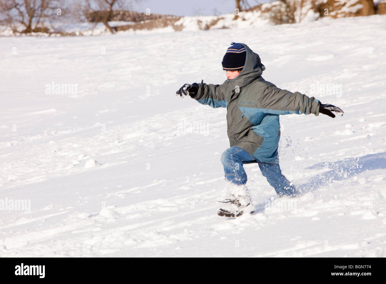 A young boy running in the snow, UK Stock Photo - Alamy