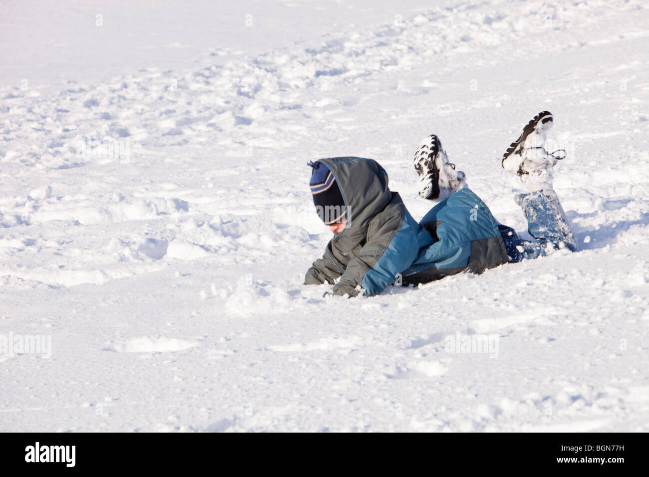 A young boy falling over in the snow, UK Stock Photo - Alamy