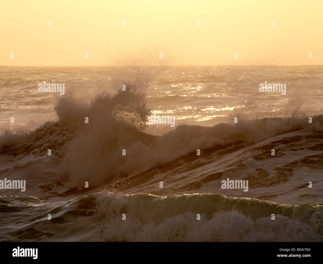 Waves and spray at sunset Stock Photo - Alamy