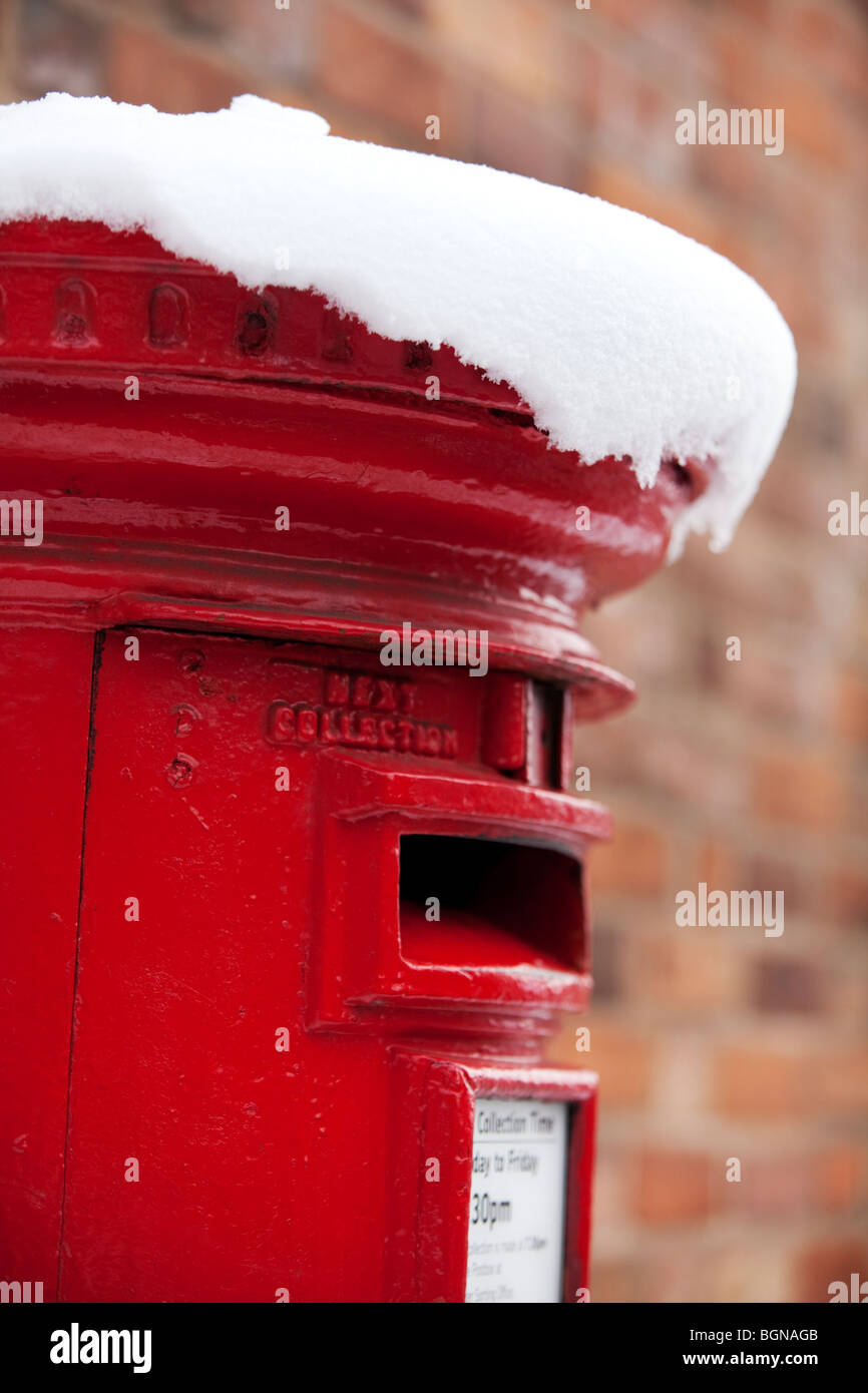 A traditional red pillar box covered in snow in Worcester, UK Stock ...