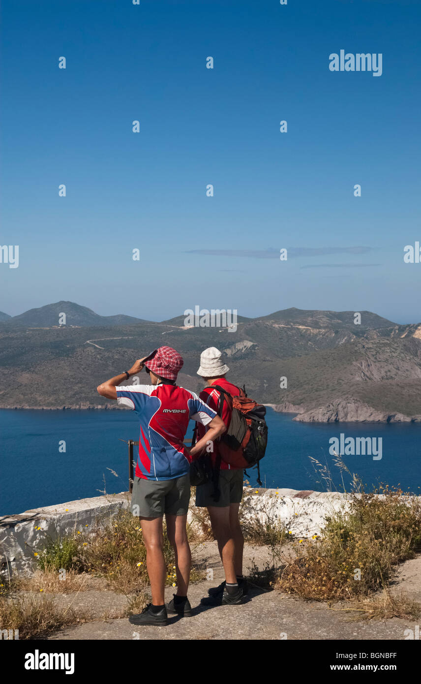Hikers admire the view at the highest point of the Kastro, Milos Island ...